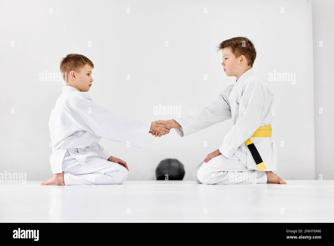 Shaking hands after fight. Boys, children in white kimono, future judo ...