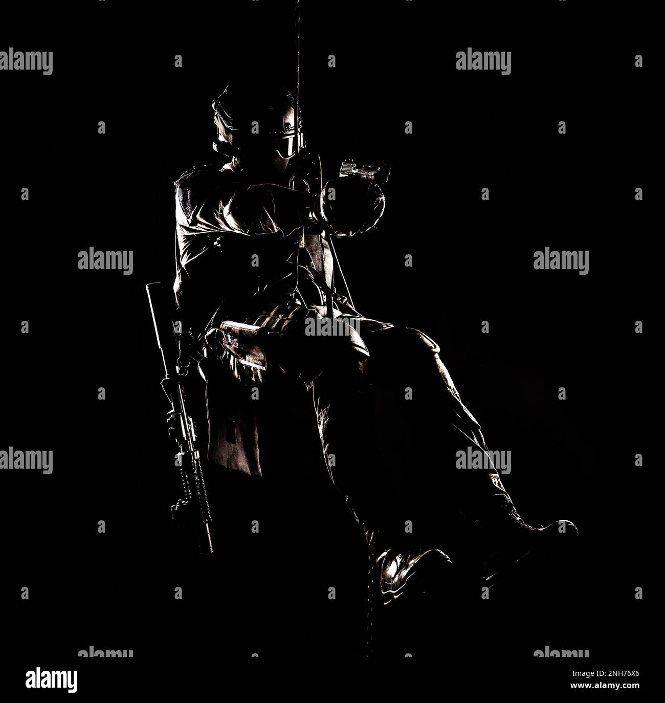 Silhouette of police officer in tactical gear descending from a height ...