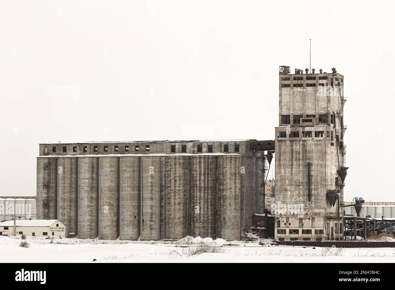An old concrete grain silo and other industrial structures in a rural ...