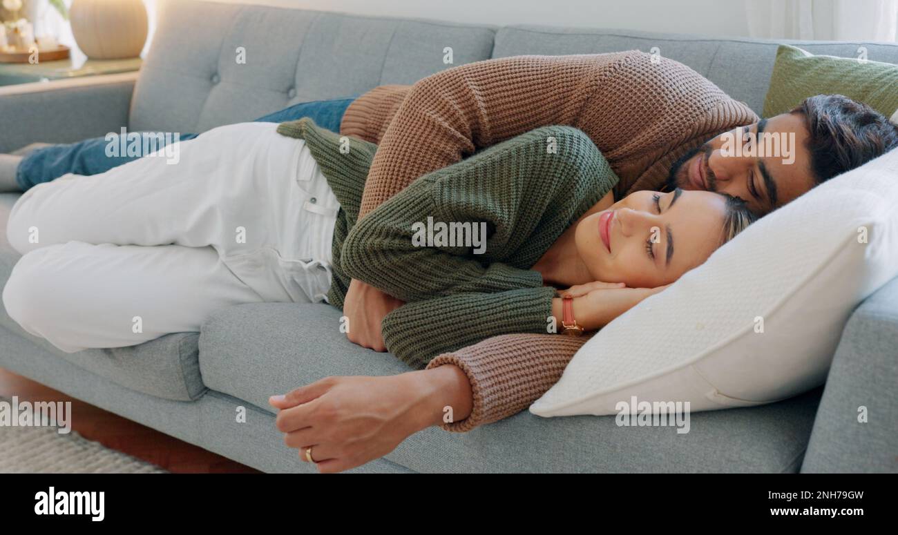 Kiss, smile and couple sleeping on the sofa in the living room of their ...