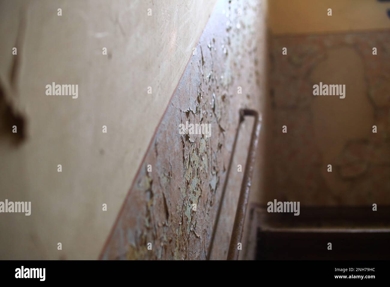 Destroyed wallpaper and staircase railing in an abandoned building ...