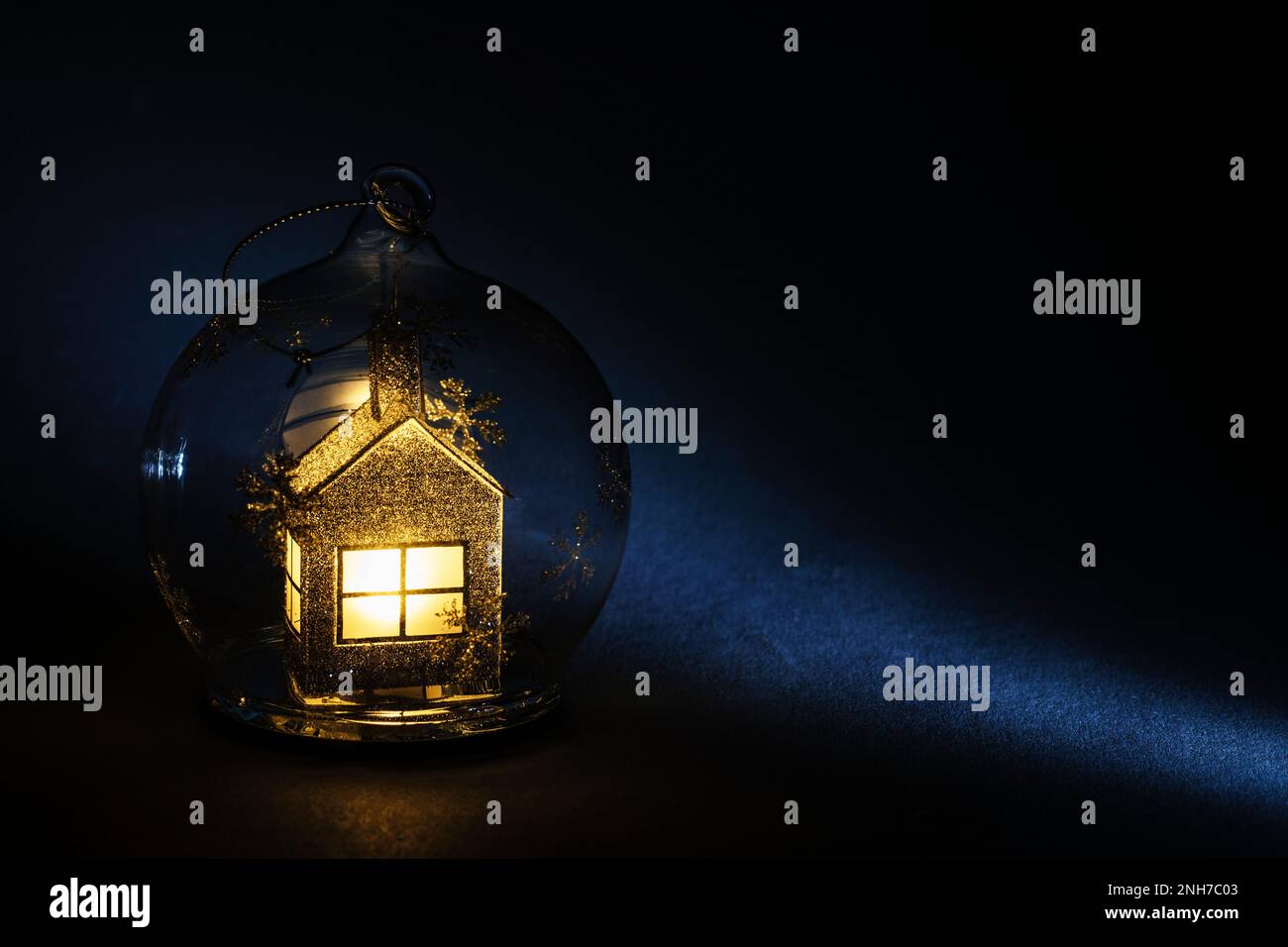 Transparent Christmas ball with a luminous golden shiny house building ...