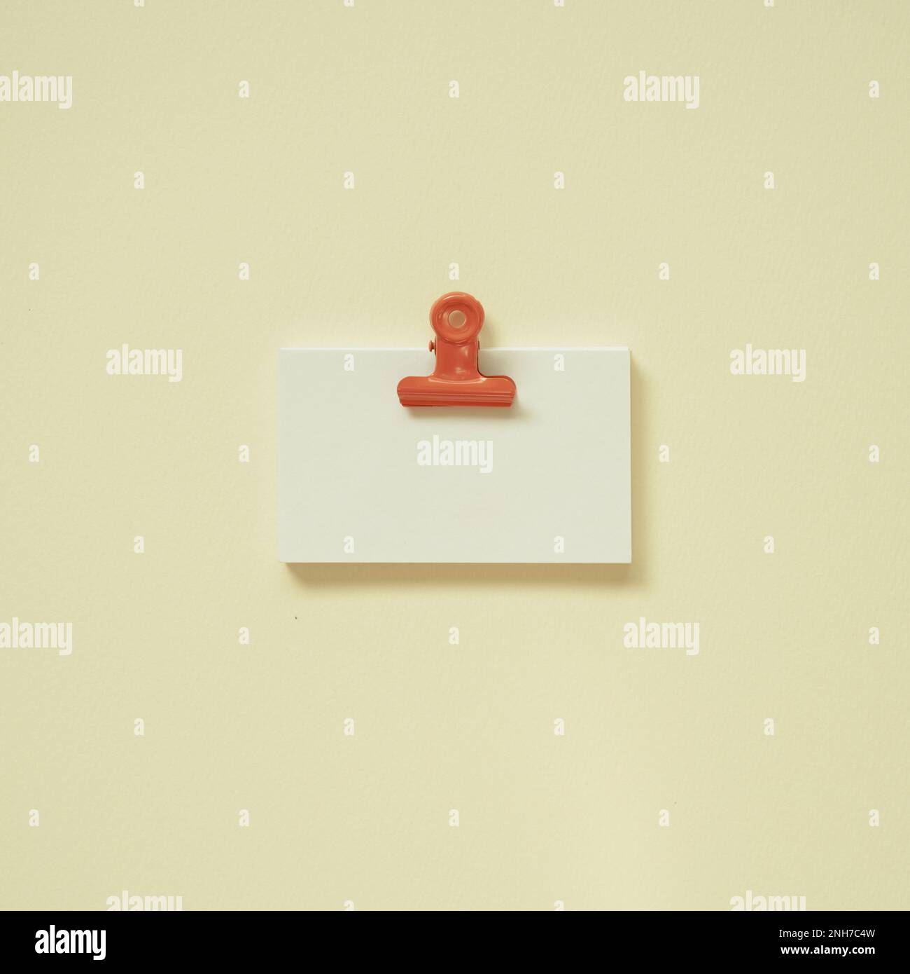 Blank white memo paper with coral clip on yellow desk background. top ...