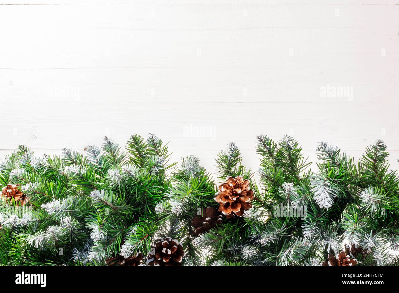 Christmas border composed of snow-covered fir branches and cones on ...