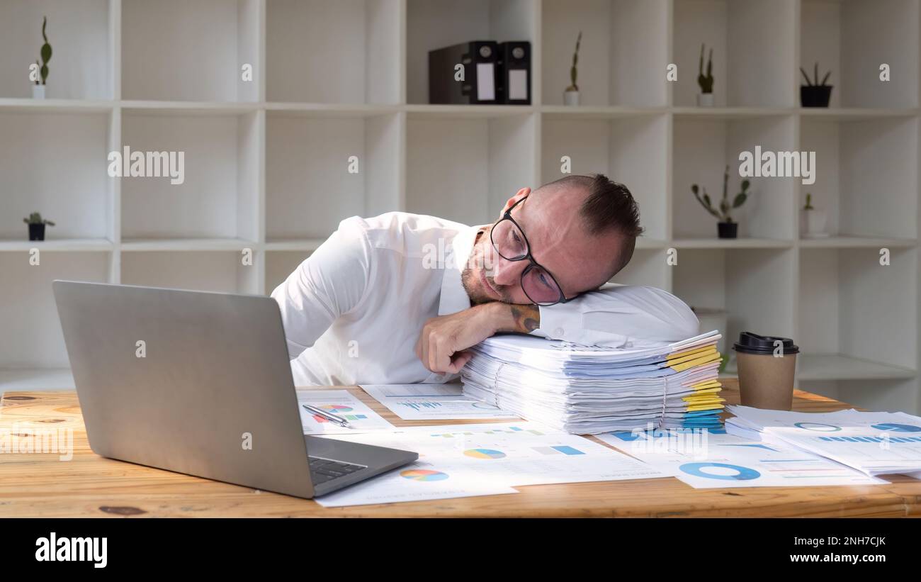 Stressed business man sitting at office workplace. Tired and overworked ...