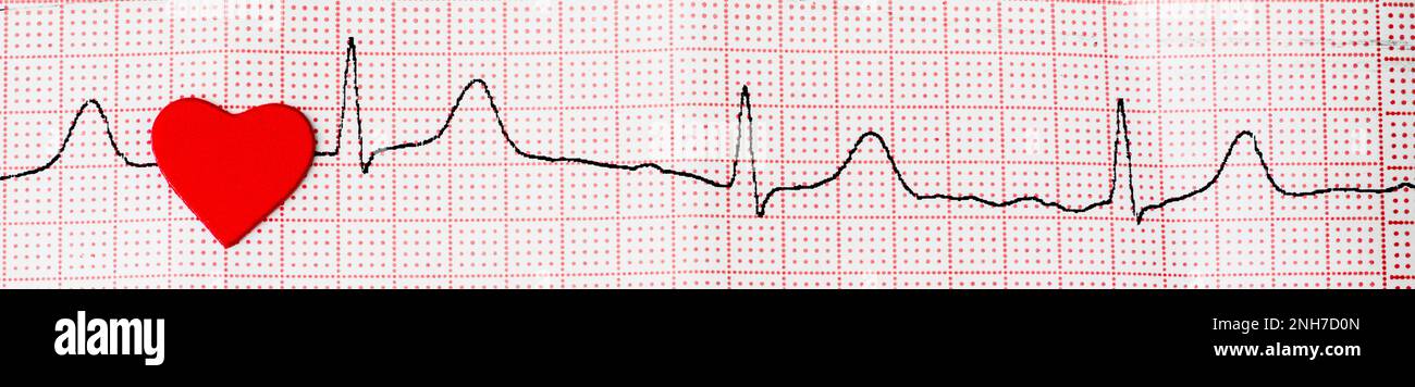 Red heart on a cardiogram, a heartbeat symbol. Close up of an ...