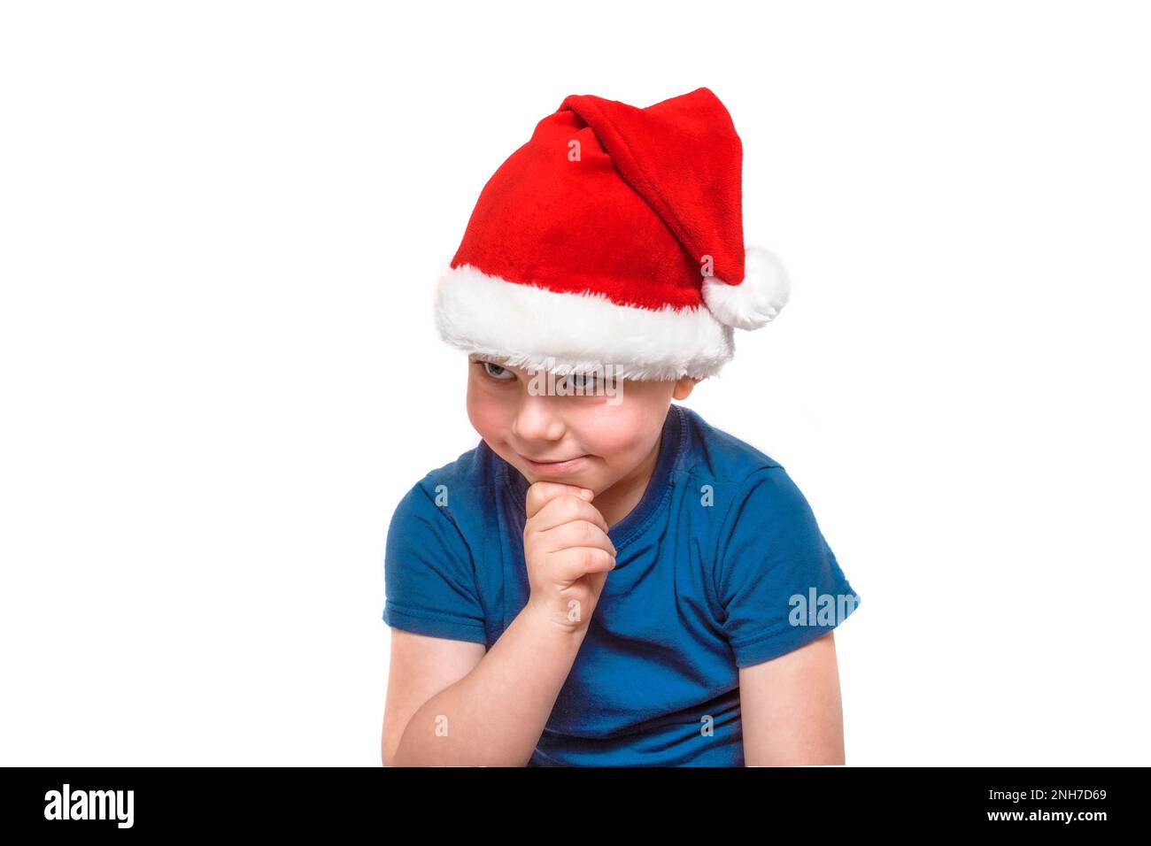 A child in a Santa Claus hat and classic blue clothes laughs, thinks ...