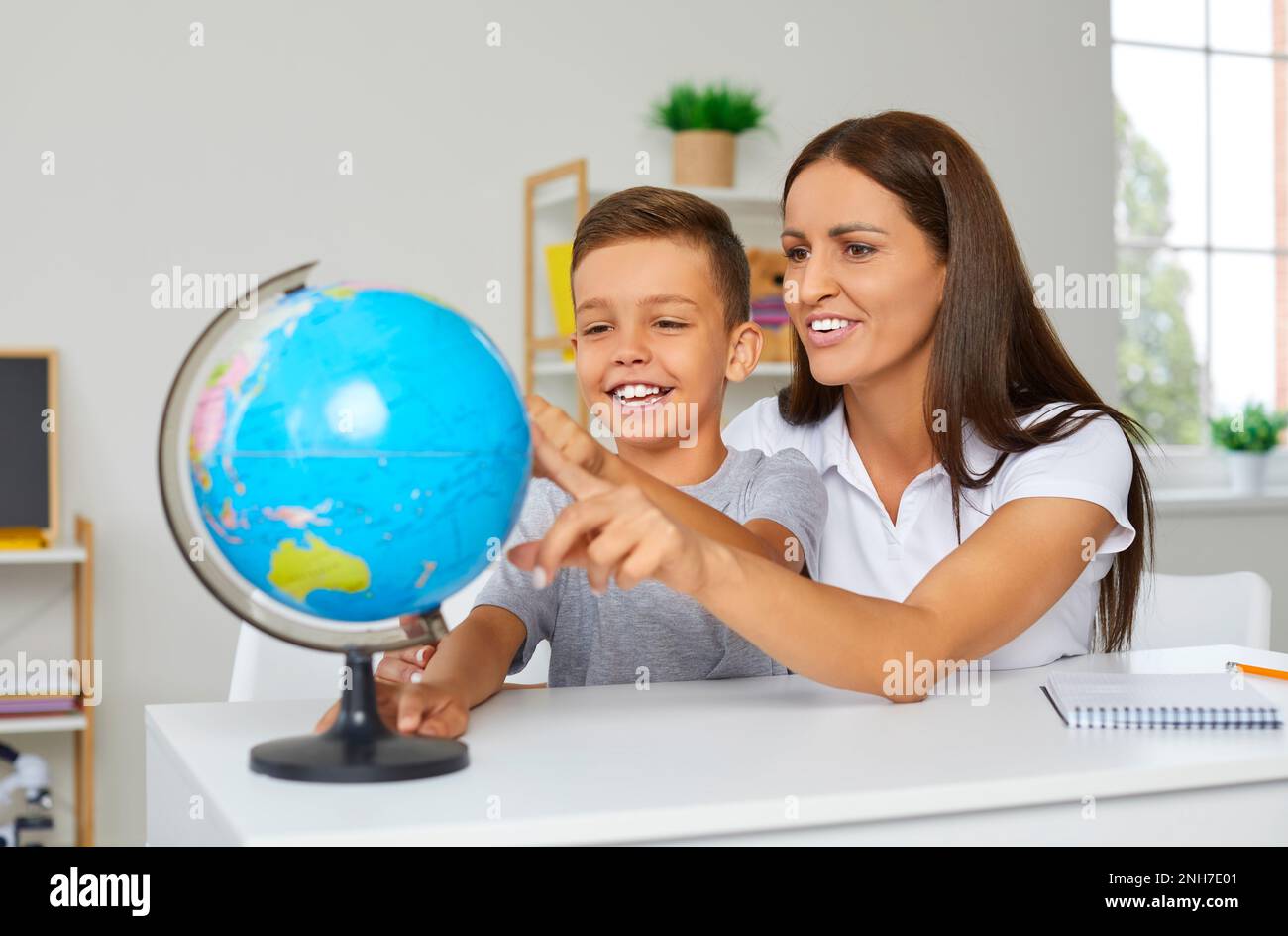 Happy mother and child learning about the world, looking at an Earth ...