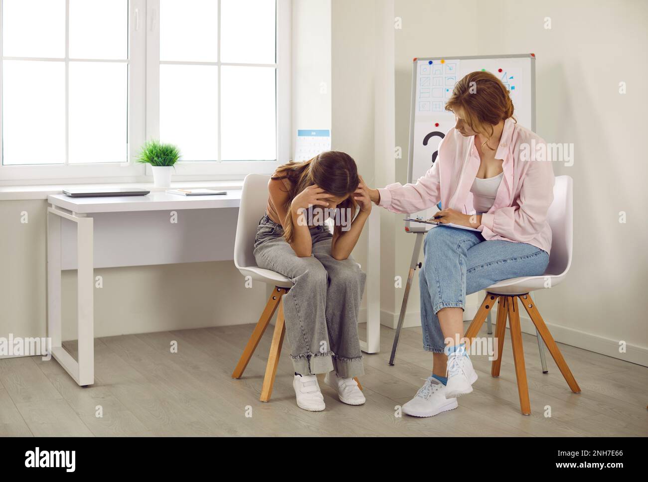 Female school psychologist supporting sad teenage girl during her ...