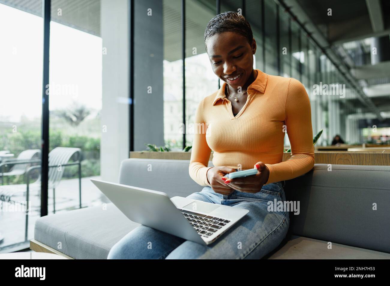 African female student working on computer in public place Stock Photo ...
