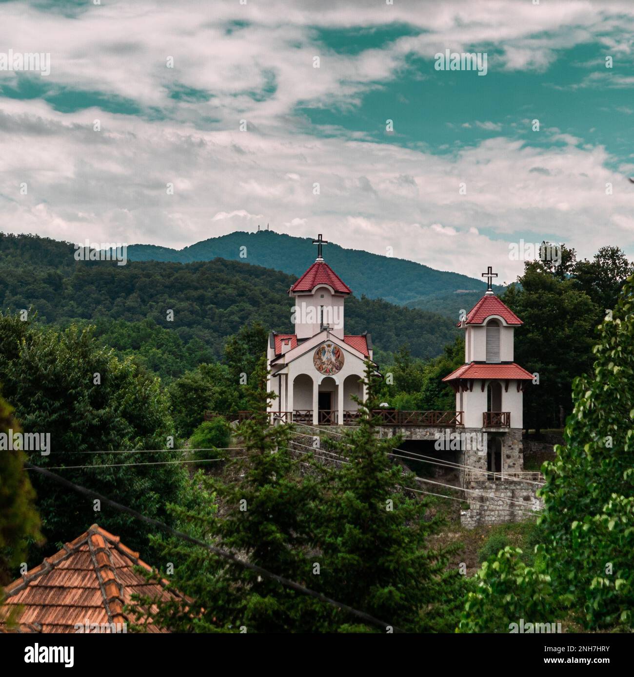 A picturesque landscape featuring two red-roofed churches perched atop ...