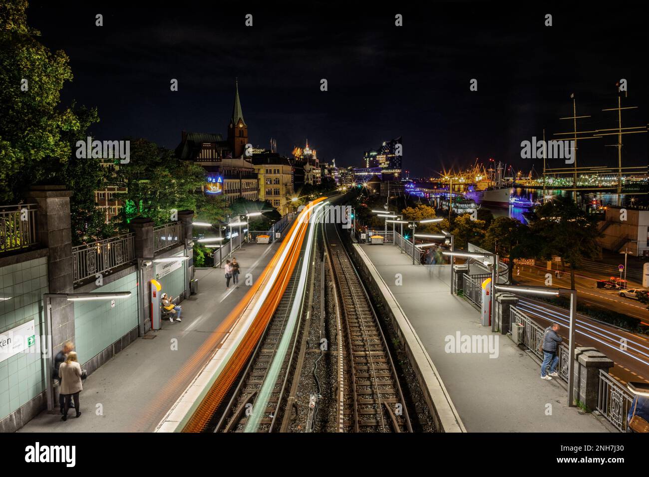 A metro train moving through a bustling metropolitan cityscape at dusk ...