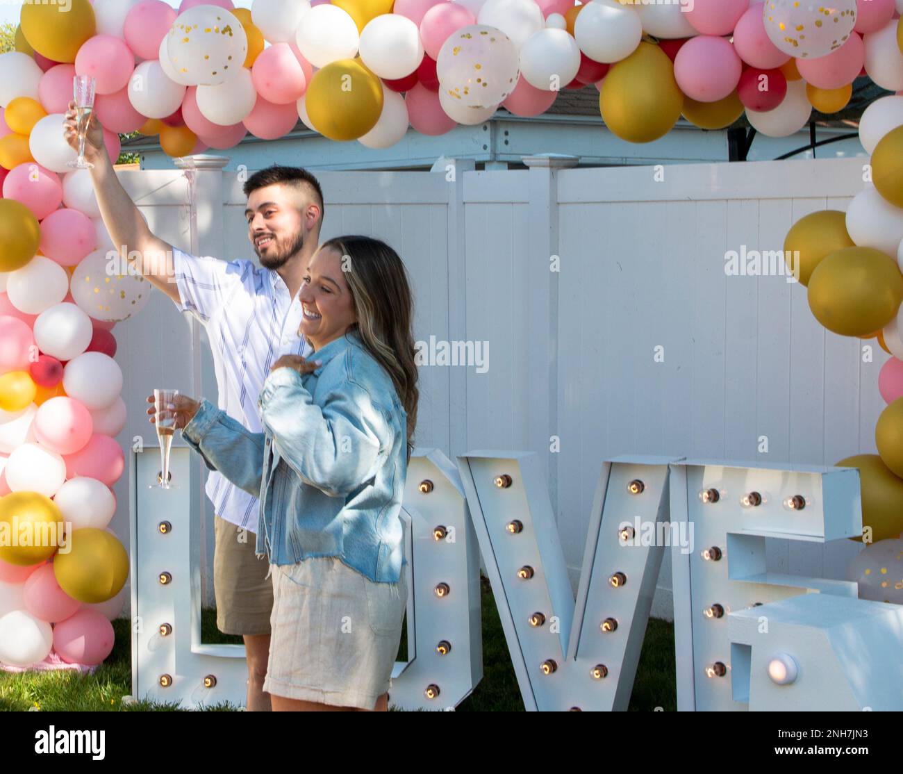 Just engaged couple raising a glass of champaign to their family ...
