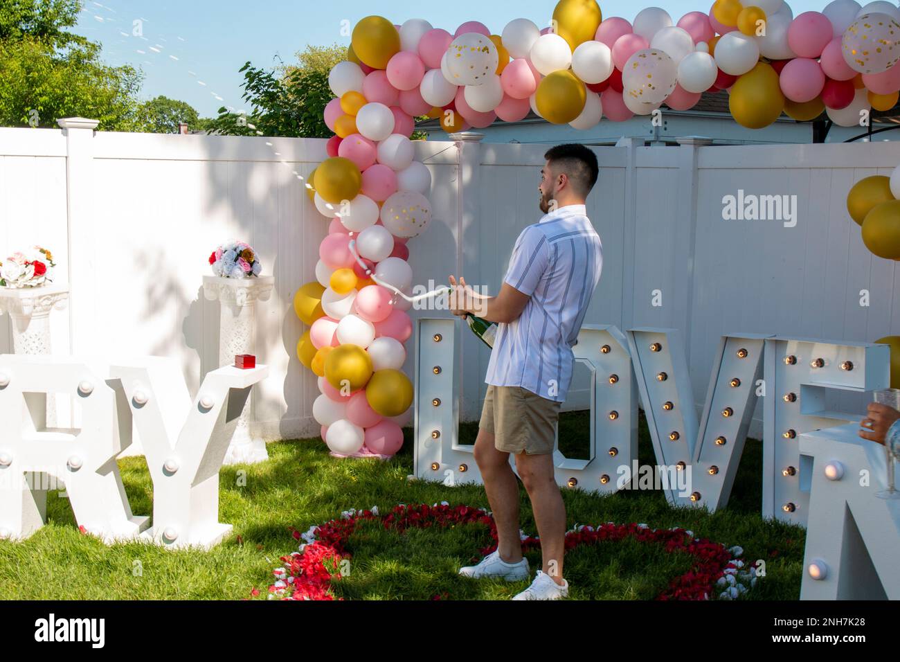 Just engaged man popping a bottle of champaign after she said yes in ...