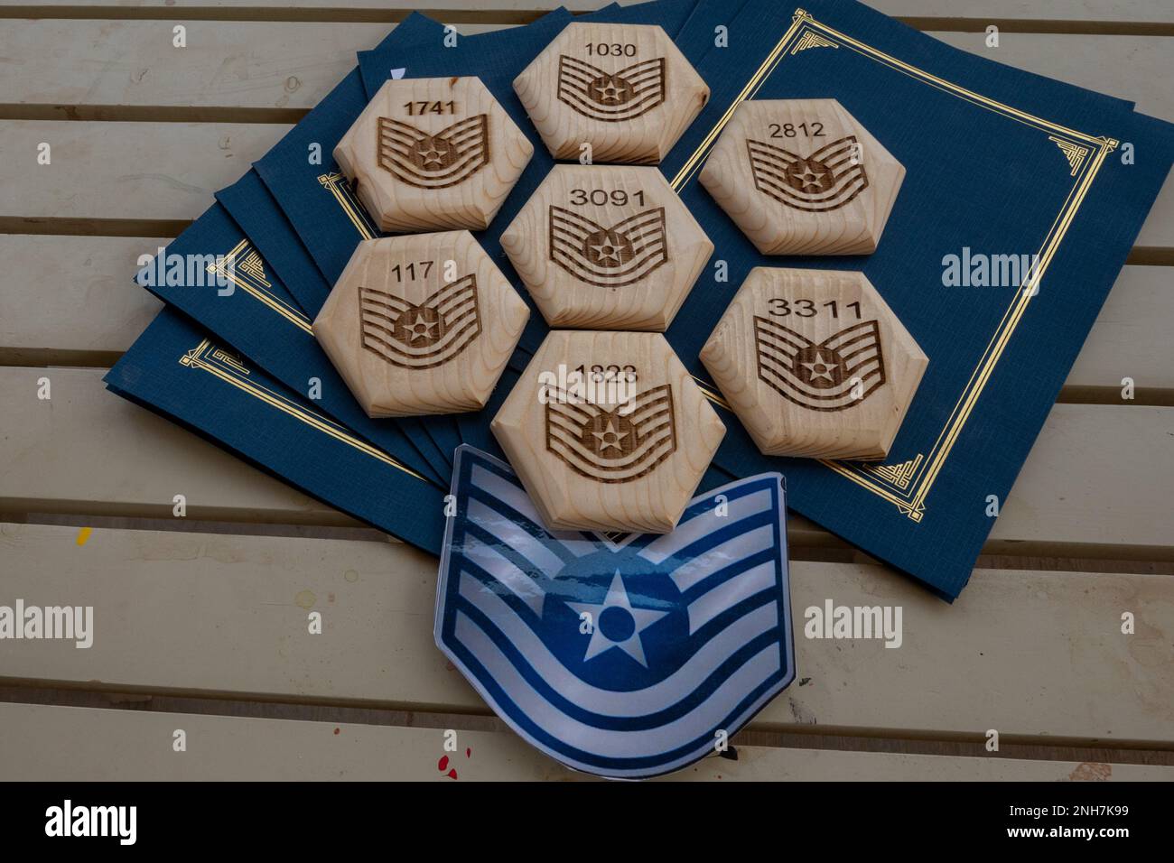 Hand-crafted wooden plaques, and certificates are displayed on a table ...