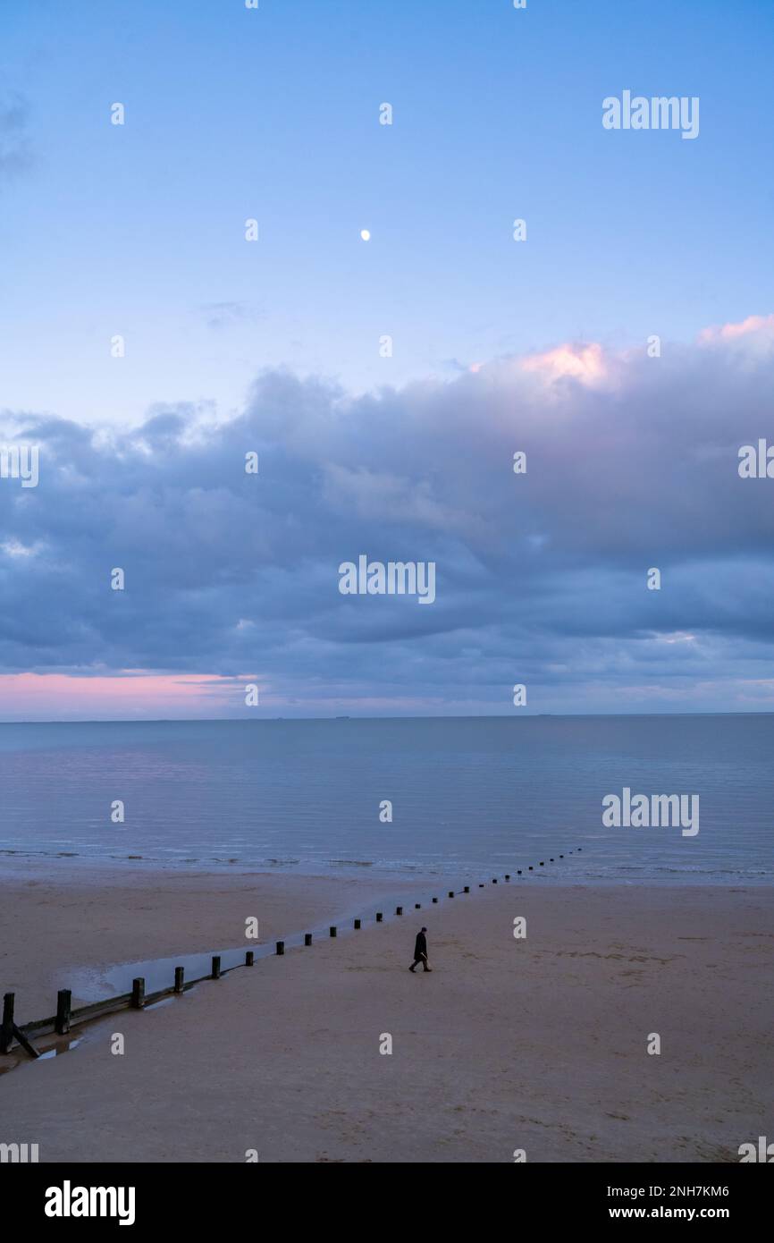 Walker on the beach at Walton on the Naze Essex Stock Photo - Alamy