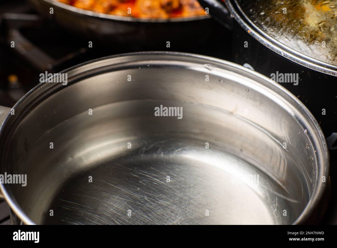 Water in a pot is on the stove in the kitchen. Preparation for boiling ...