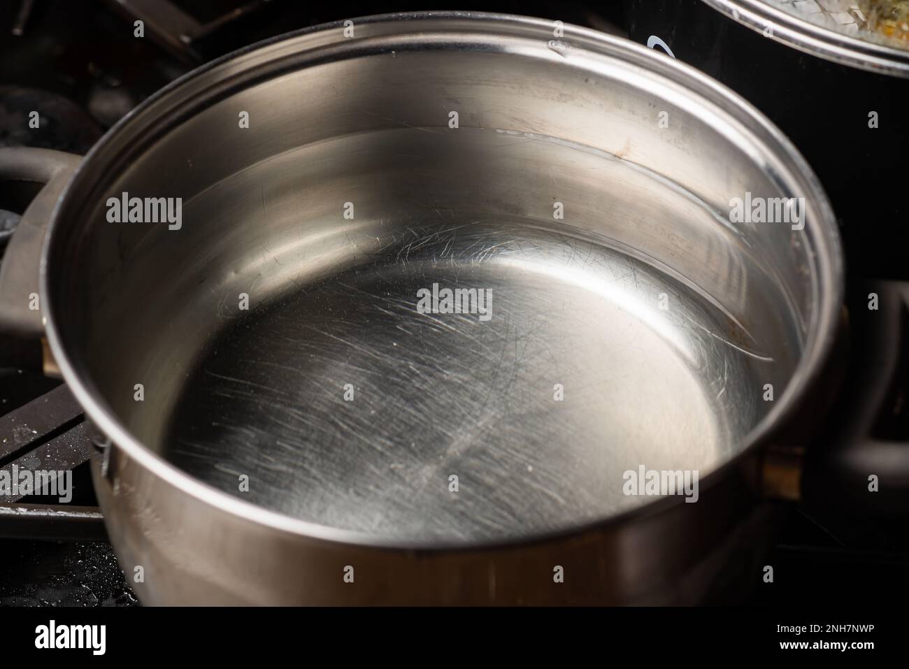 Water in a pot is on the stove in the kitchen. Preparation for boiling ...