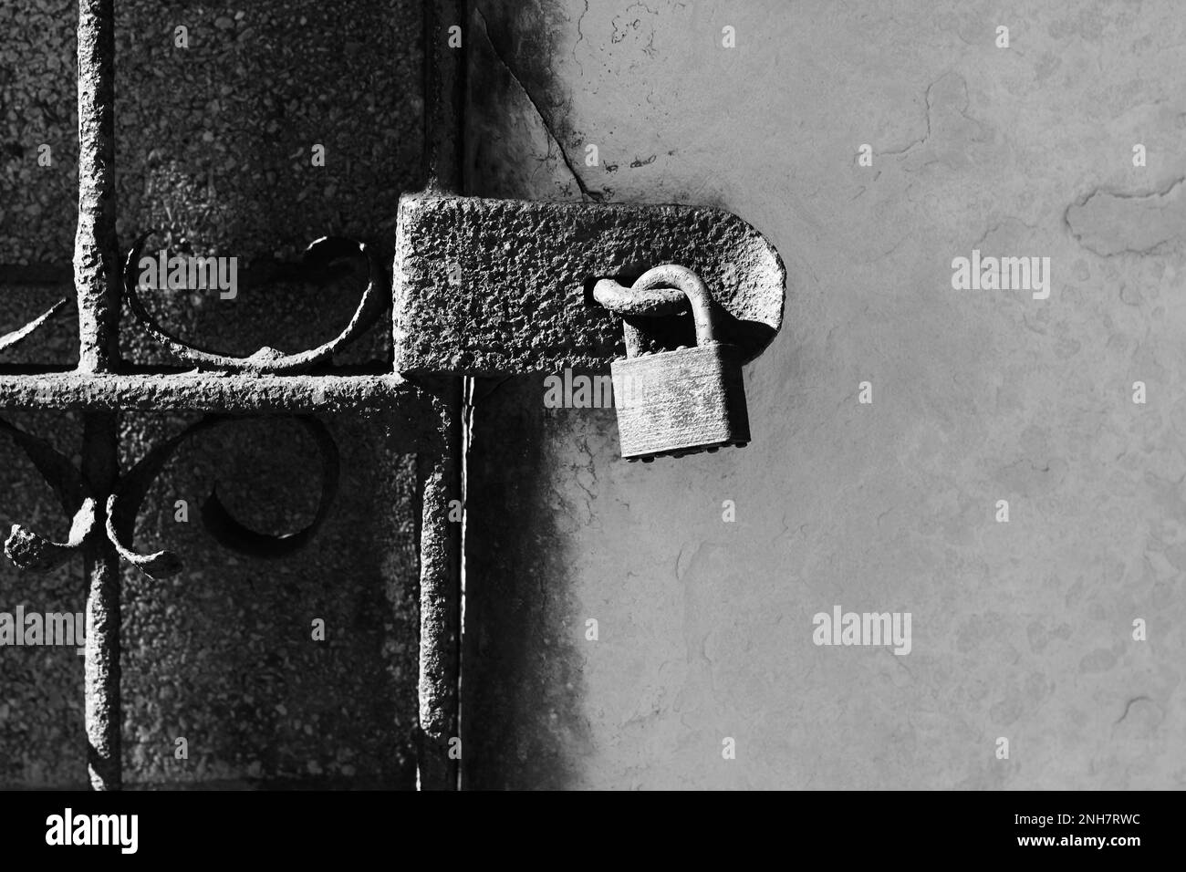 Vintage traditional old rusted metal lock keeping a gate closed in a ...