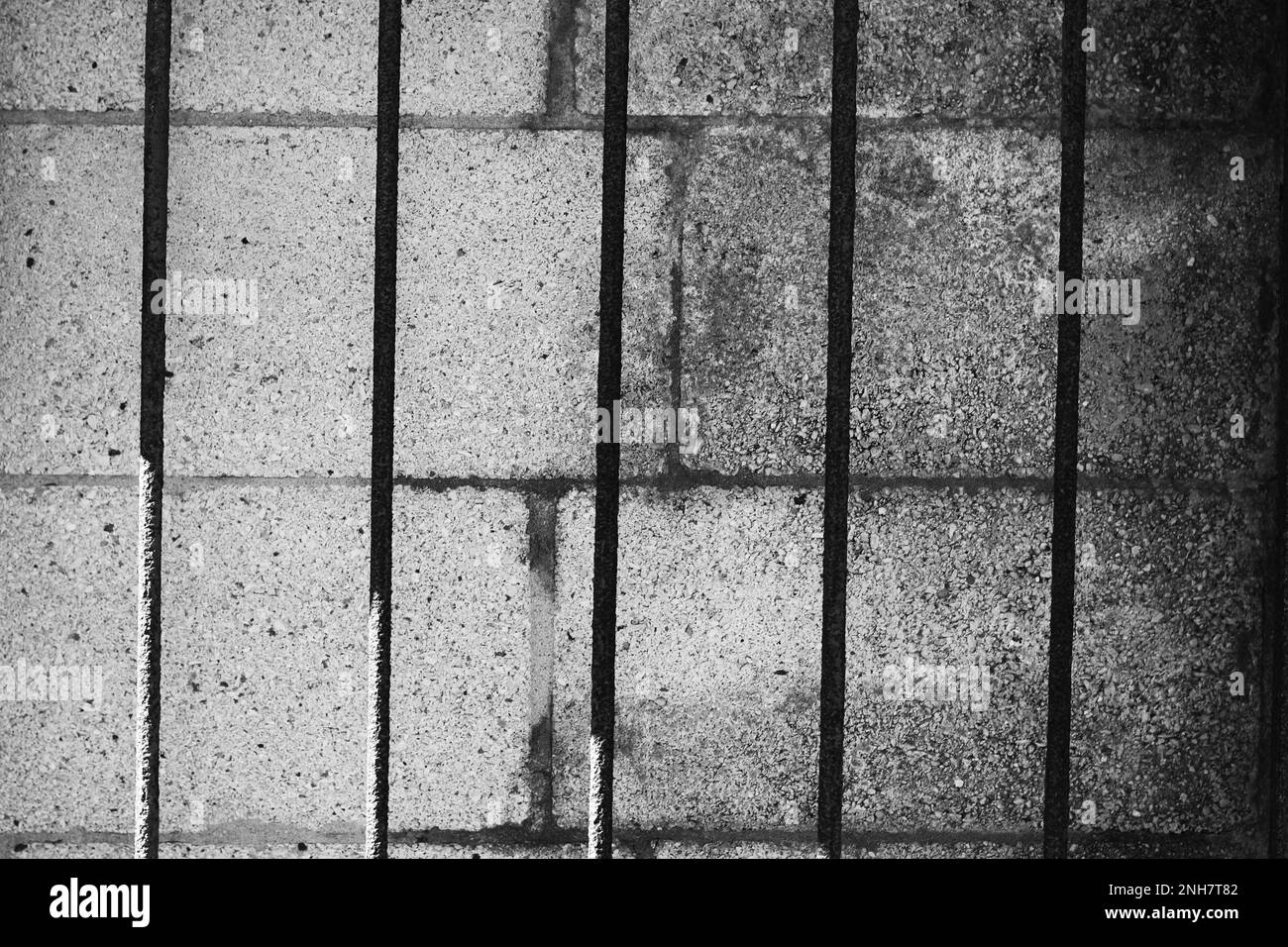 Old rusty prison bars with a brick wall in a black and white monochrome ...