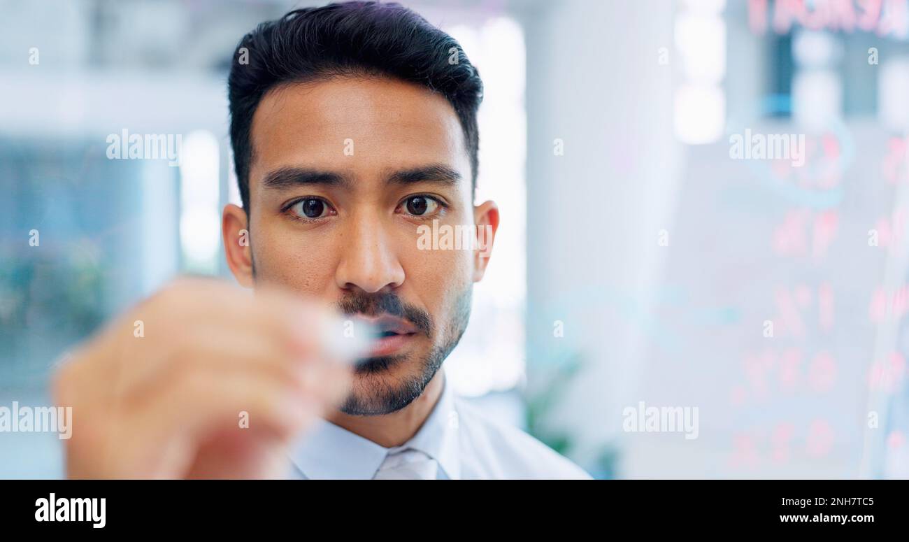 Thinking, strategy and serious businessman writing on glass wall with ...