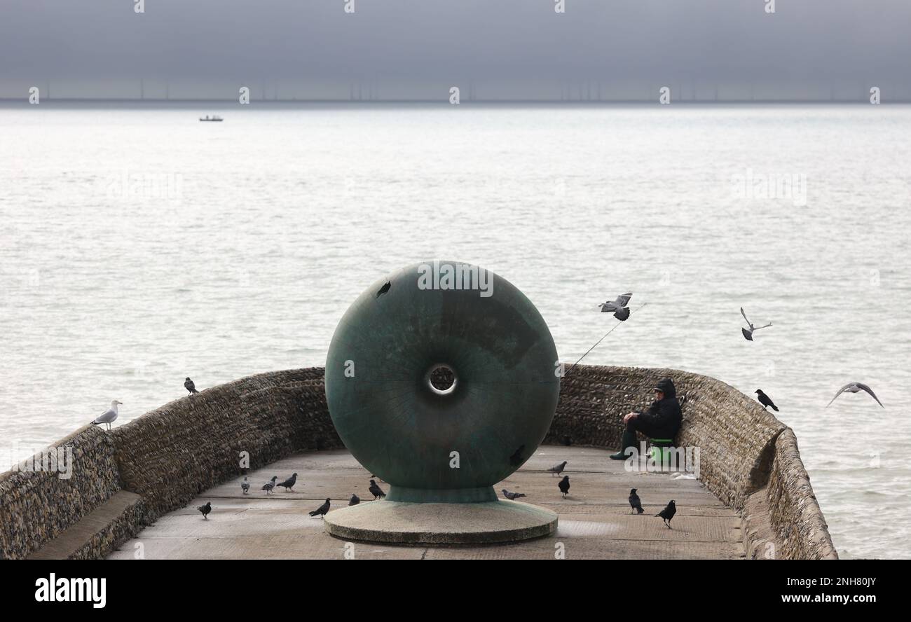 Brighton, UK. 21st Feb, 2023. A man fishing at the end of the groin by ...