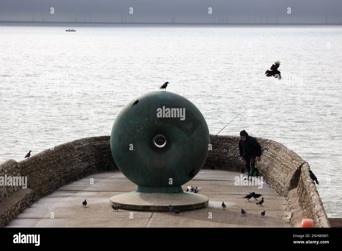 Brighton, UK. 21st Feb, 2023. A man fishing at the end of the groin by ...