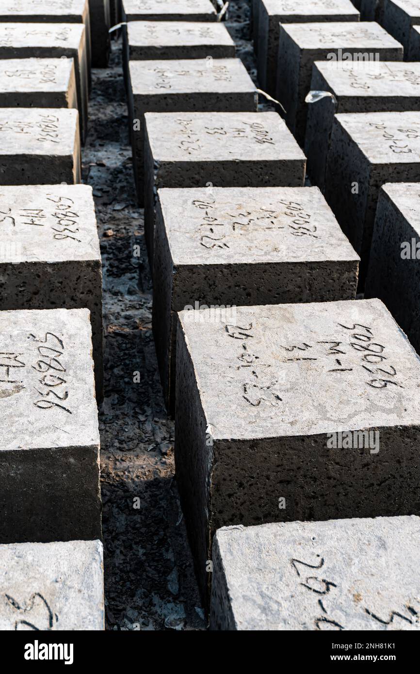 Portrait view of concrete cube over block background. Rock bolder. Four ...