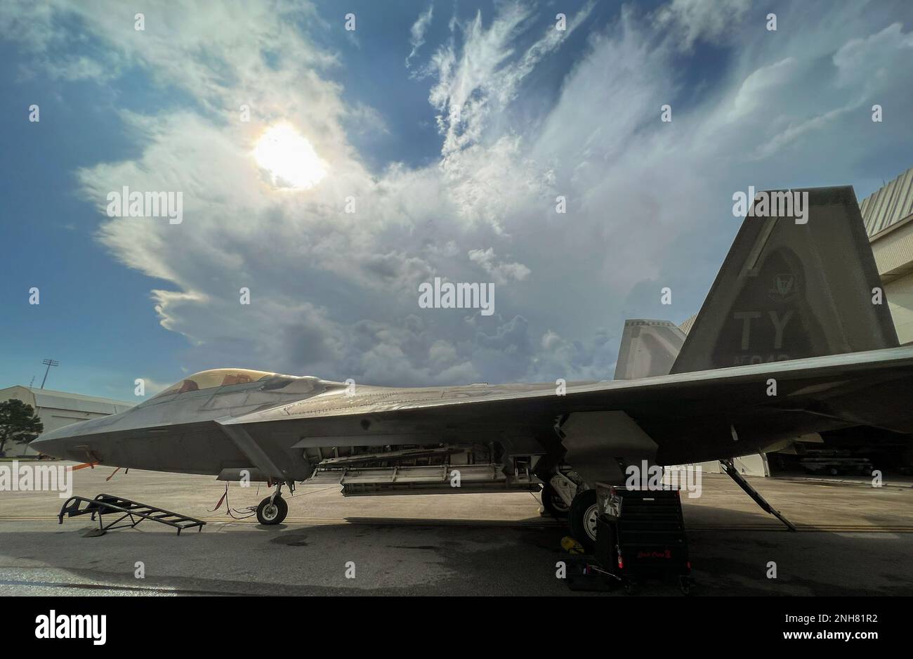 A 325th Fighter Wing F-22 Raptor sits on the flightline as storm clouds ...