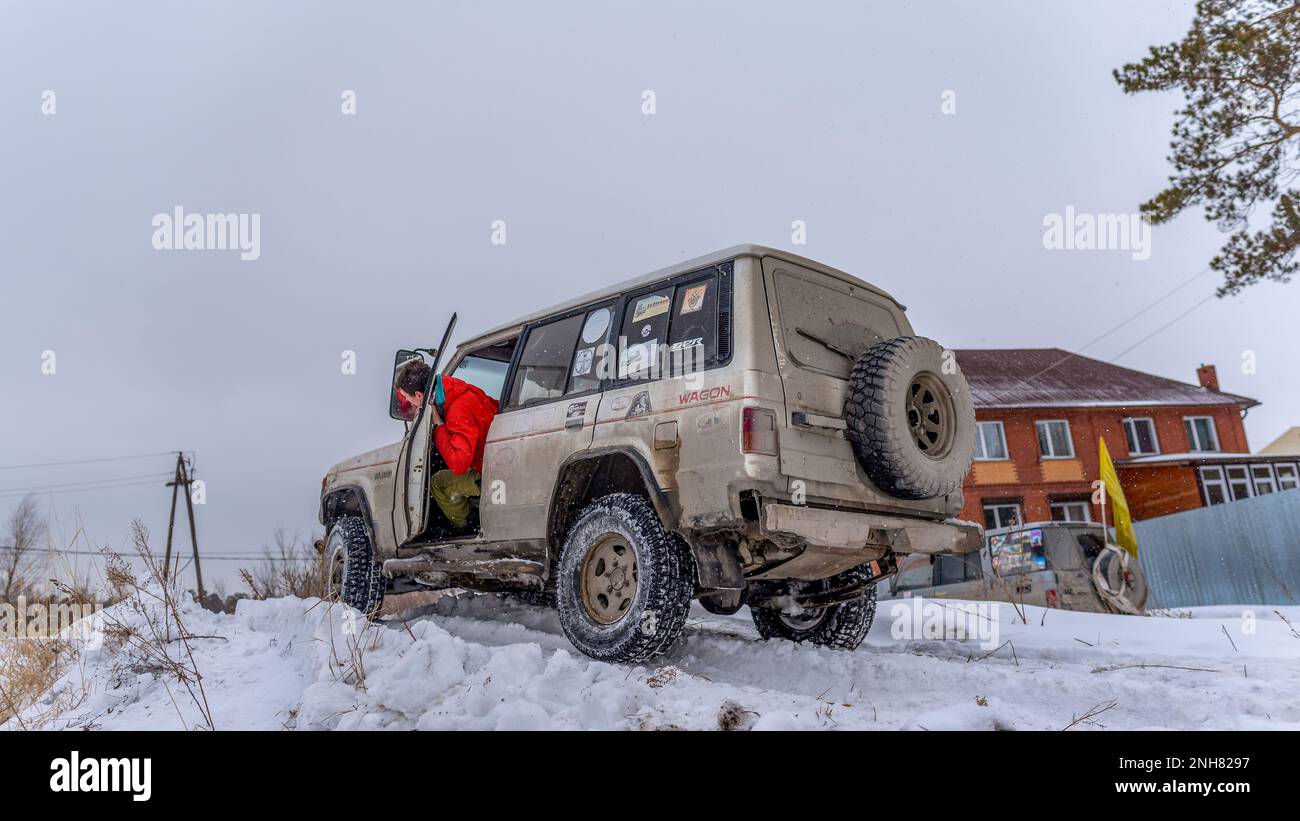 Off-road SUV "Mitsubishi Pajero" 4x4 drives on a snow slide in winter ...