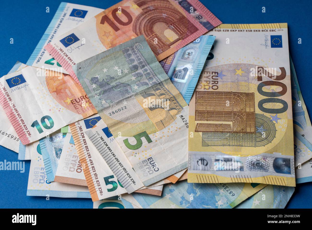On the table is a pile of banknotes in denominations of five, ten ...