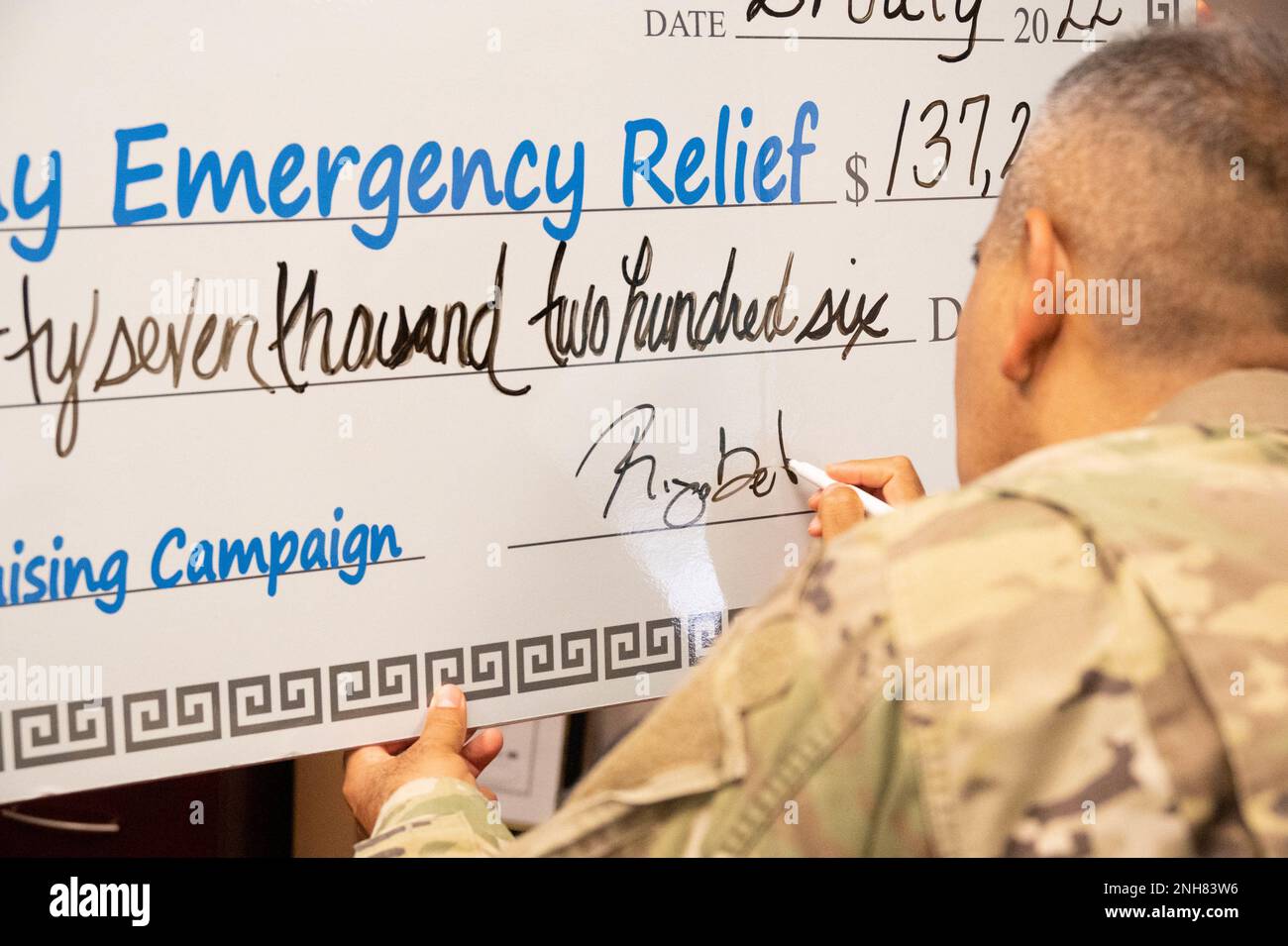 Garrison Command Sgt. Maj. Cesar Duran signs the ceremonial donation ...