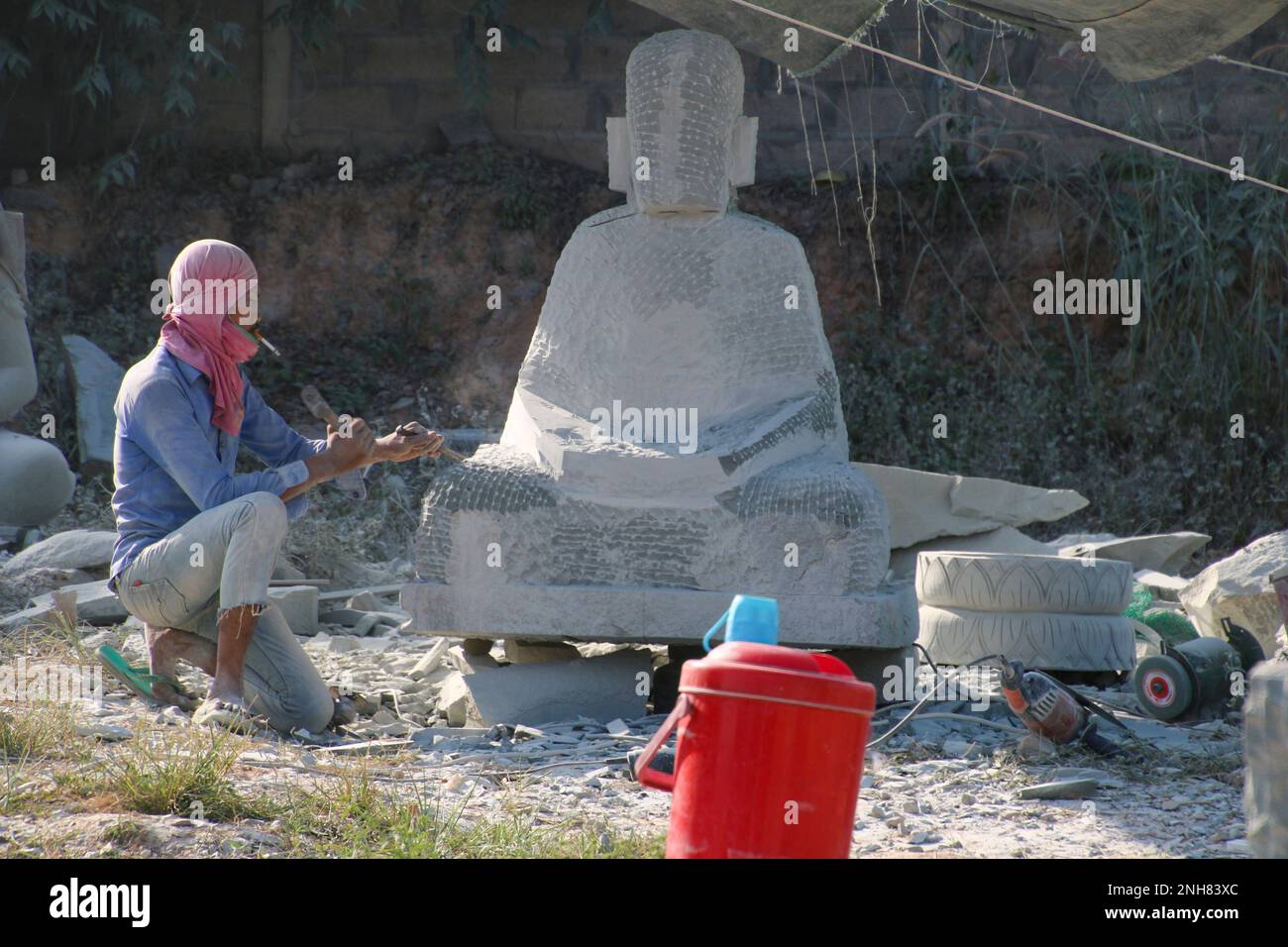 Local stonemason at work, fashioning buddha statues, Photographed in ...