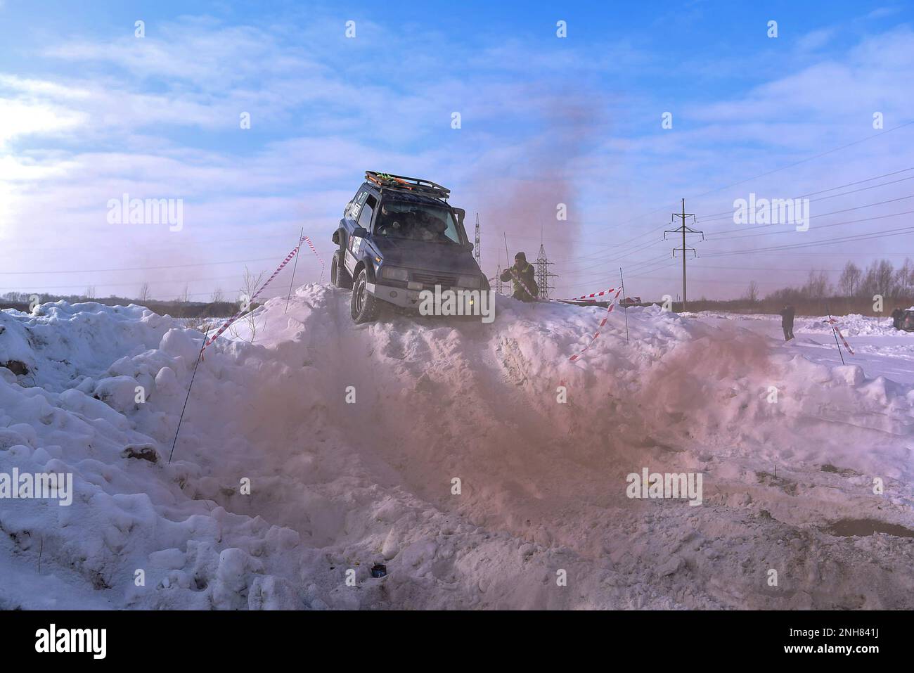 Offroad SUV "Suzuki Escudo" 4x4 rides on a snowy mountain in the clouds ...