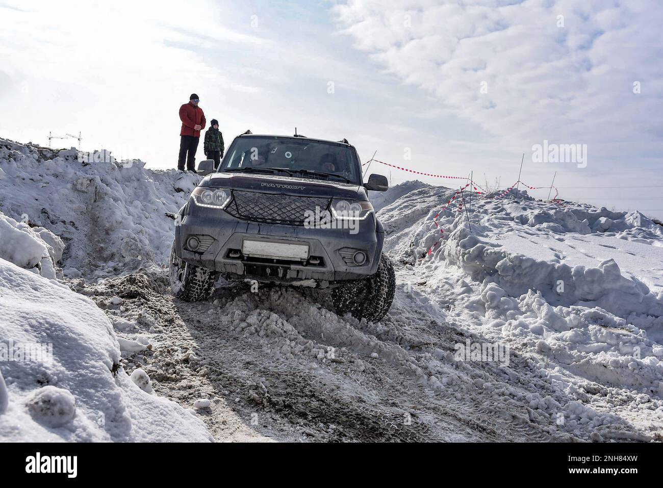 Russian SUV "UAZ Patriot" quickly goes on a snowy road in the field in ...