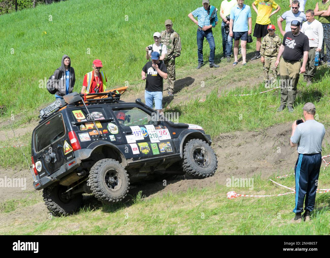 Crowd of spectators looking at the car "Suzuki Jimny" which is highly ...