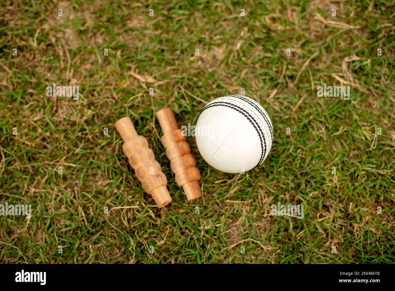 Cricket ball and bail on green grass playing ground pitch Stock Photo ...