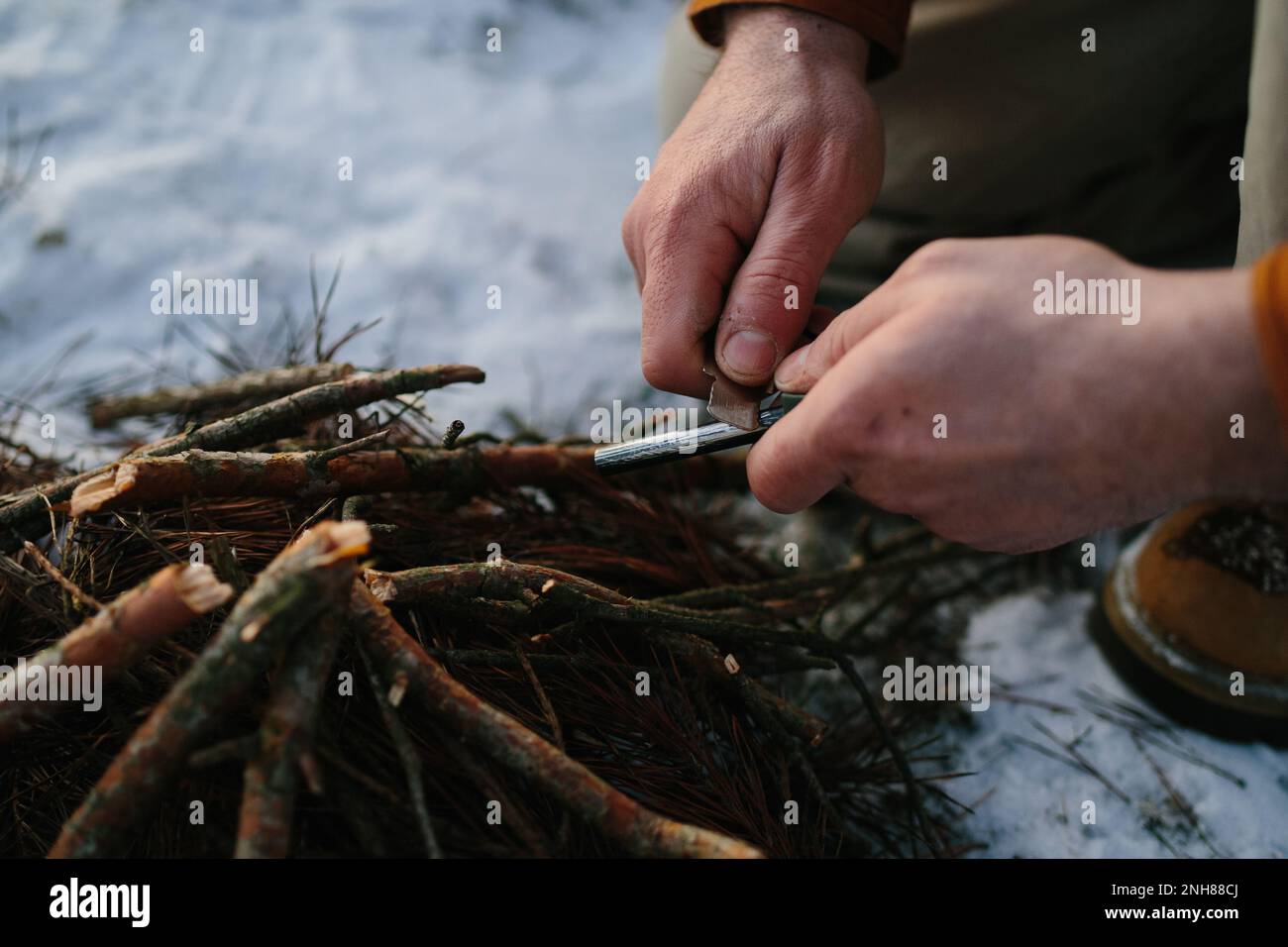 Closeup of male hand starts fire with magnesium fire steel, fire ...