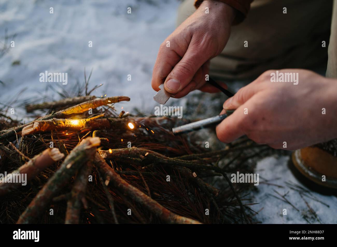 Closeup of male hand starts fire with magnesium fire steel, fire ...