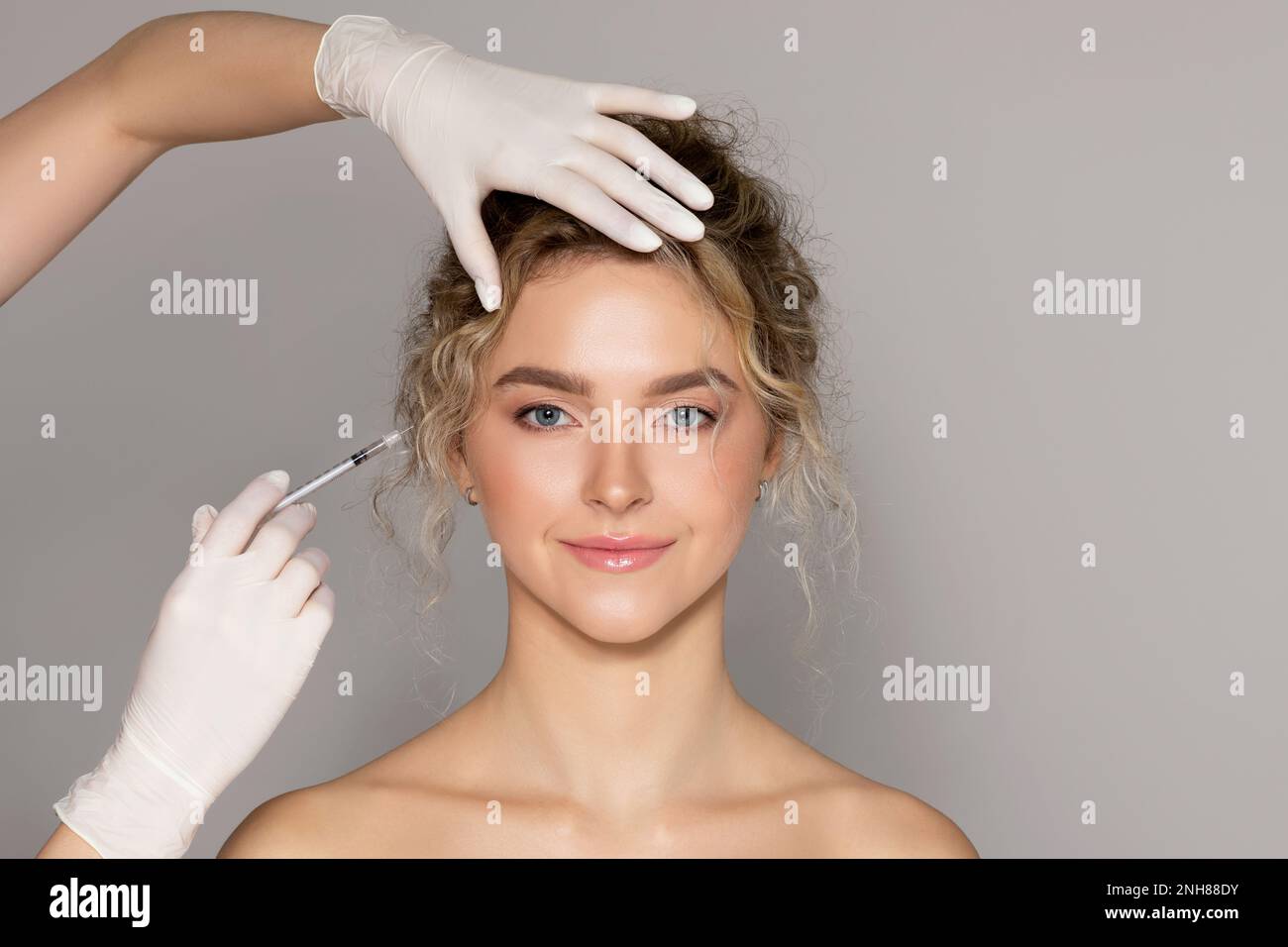 Beautiful young woman getting beauty injection in eye area from ...