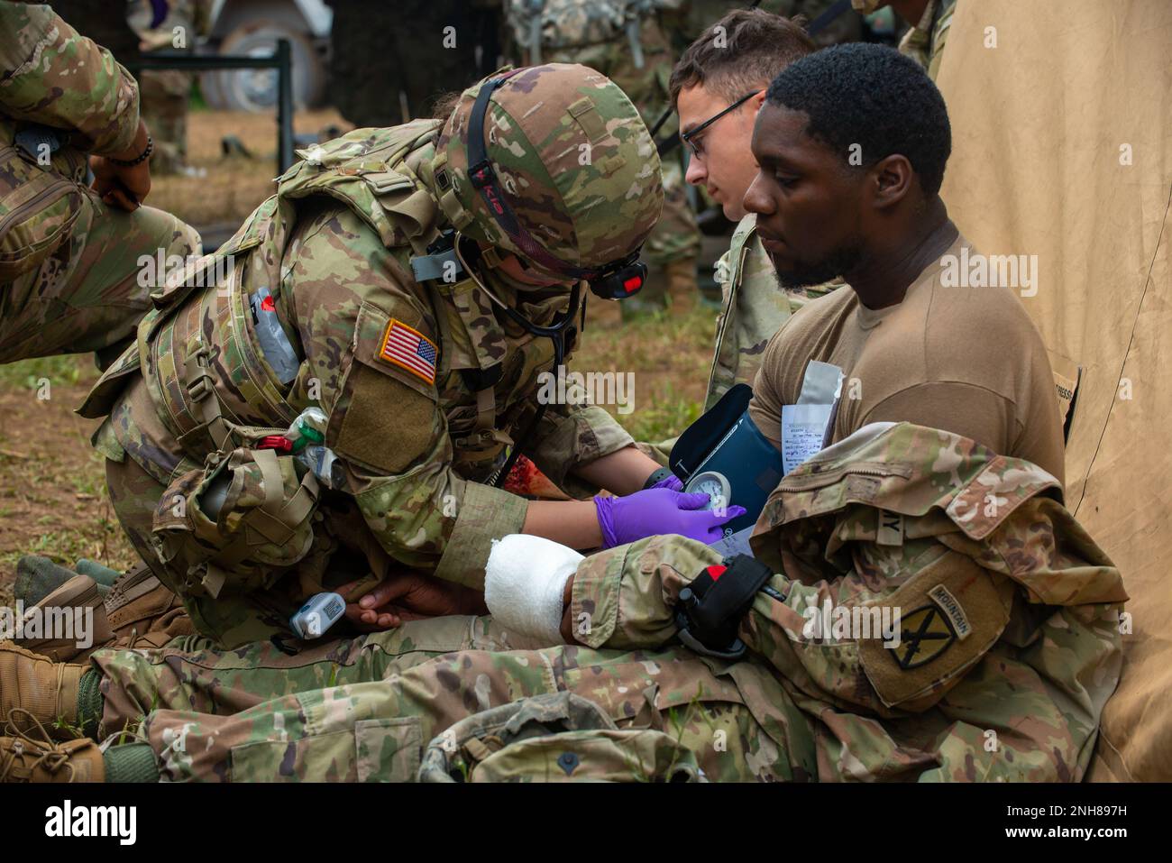 A combat medic checks the vital signs of a simulated casualty in ...