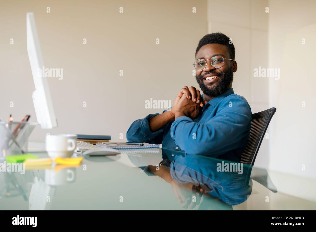 Millennial freelancer. Happy black man working with computer in office ...