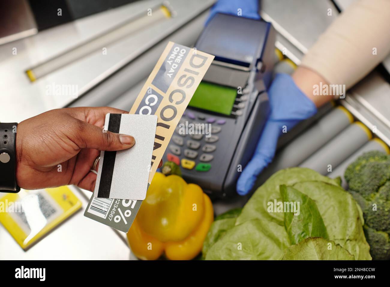 Overview of consumer hand holding credit card and discount coupon over ...