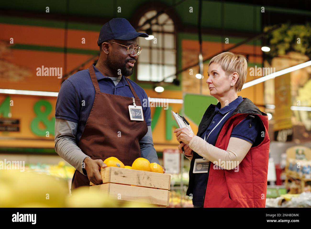 Confident mature female sales advisor with document listening to her ...