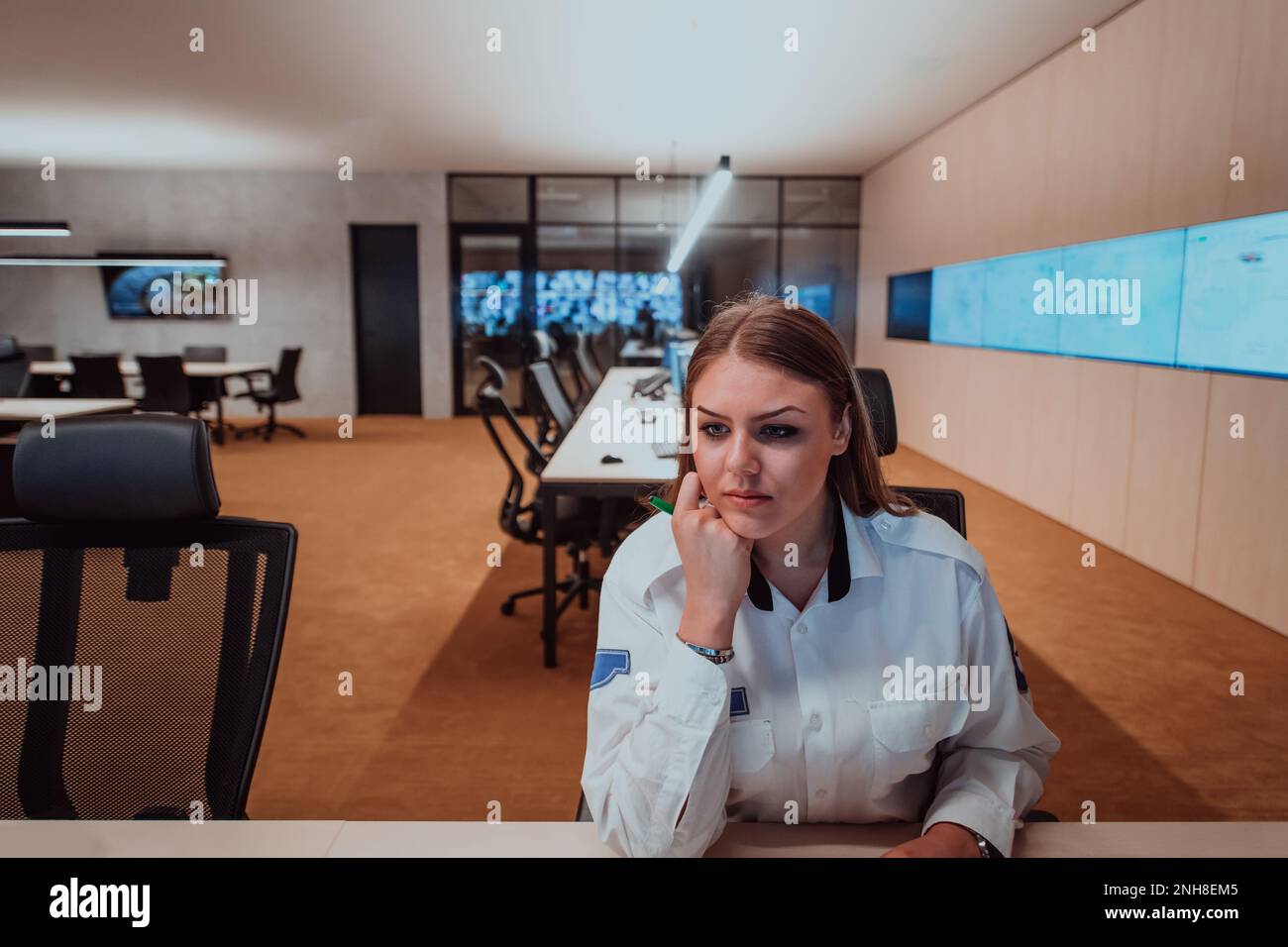 Female security operator working in a data system control room offices ...