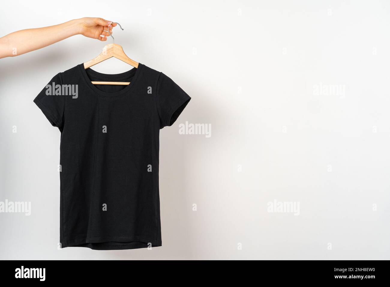Black plain t-shirt hanging on a hanger Stock Photo - Alamy