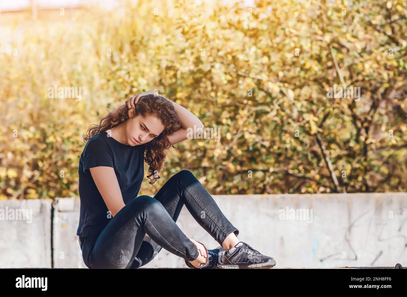 Sporty womanl sitting on ground. Hand behind head. Sunset background ...