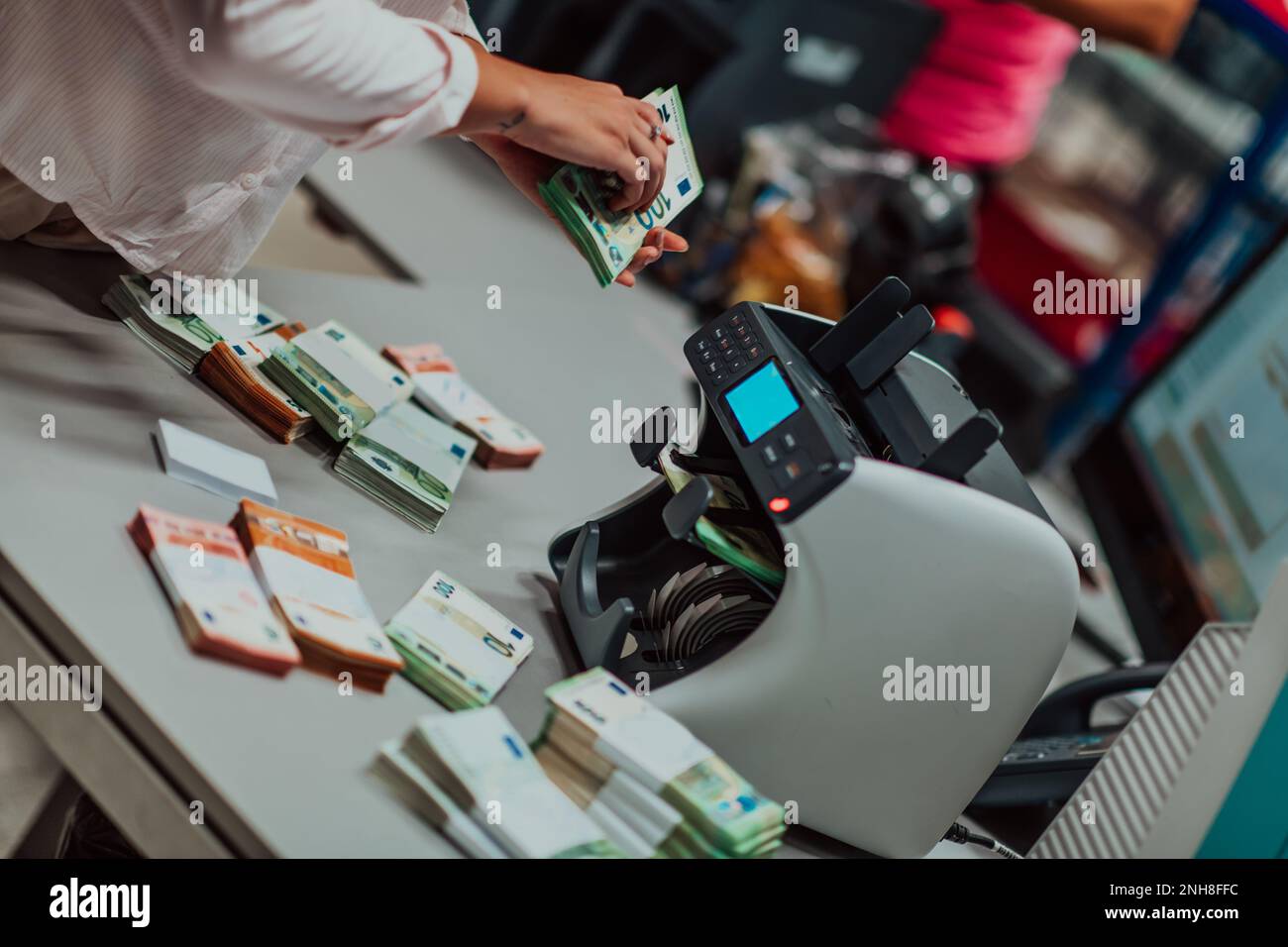 Bank employees using money counting machine while sorting and counting ...