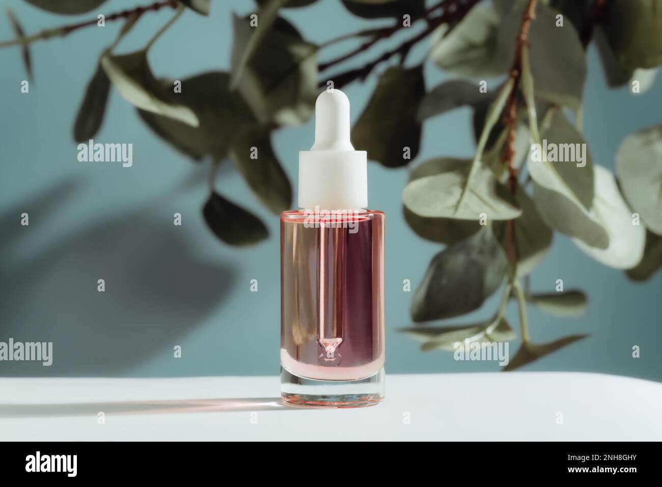 Pink face and hair oil in glass bottle with dropper pipette and white ...