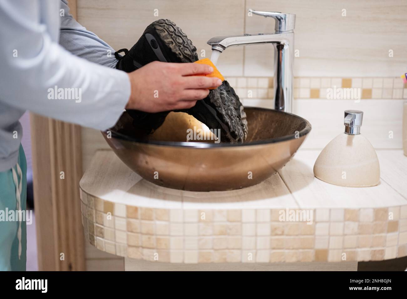 Сleaning the shoes. Man washes boots in the sink Stock Photo - Alamy